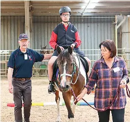 Volunteers helping riders interact with horses - PressReader