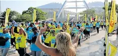Sea of turquoise and yellow floods ECR Big Walk - PressReader