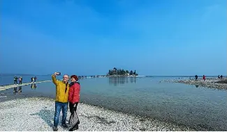 Touristen zu Fuß mitten im Gardasee: Dürre legt mysteriöse­n Pfad zur ...